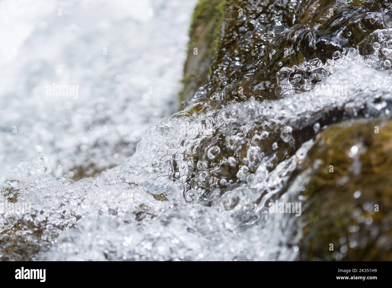 Rushing water over rocks at the bottom of a waterfall on Kaua'i, HI ...