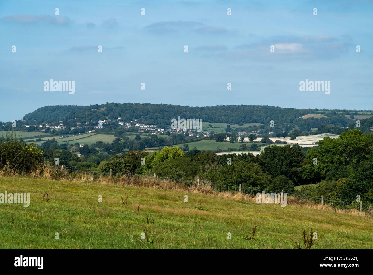 The Gloucestershire village with green fields, fence and town in ...