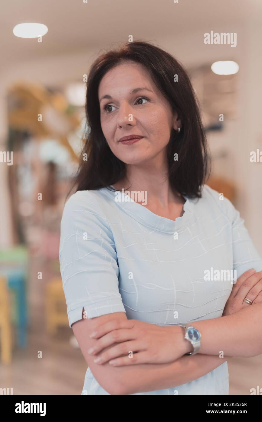 Portrait of a teacher in a preschool institution, in the background of ...