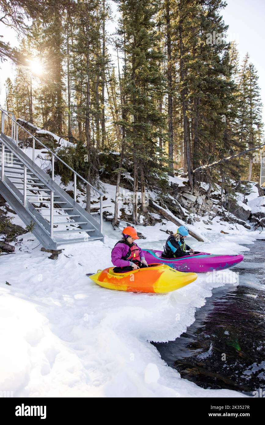 Friends sitting inside kayak on snow Stock Photo - Alamy