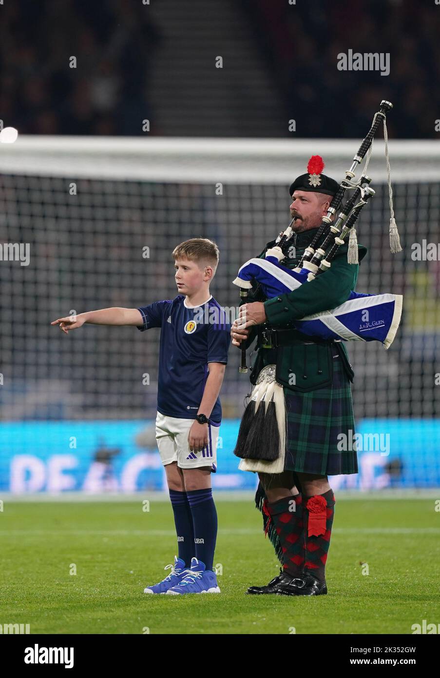 A pipe player and a boy using sign language during the national anthem ...