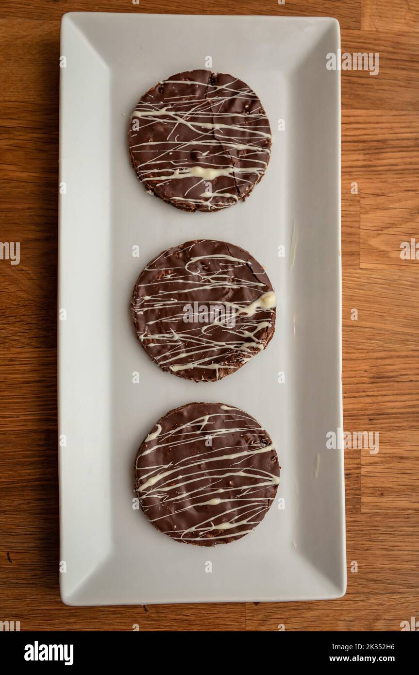 A vertical closeup shot of chocolate cookies drizzled with white ...