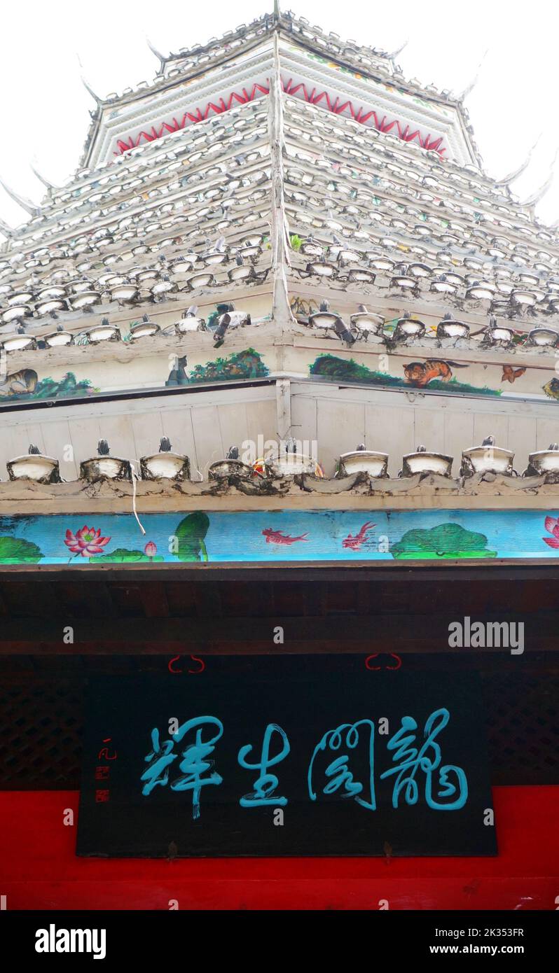 A building with paintings on the wall in Jinxiu China Folk Village ...