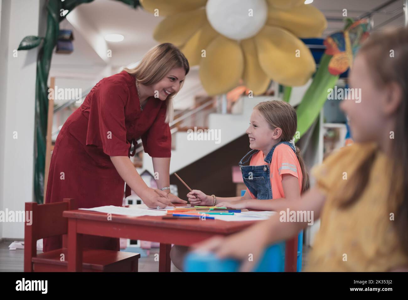 Creative kids during an art class in a daycare center or elementary school classroom drawing ...