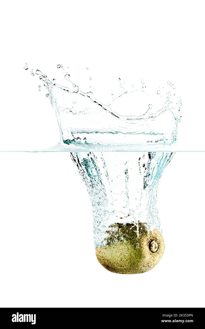 A kiwi falling into water splash on a white background Stock Photo - Alamy