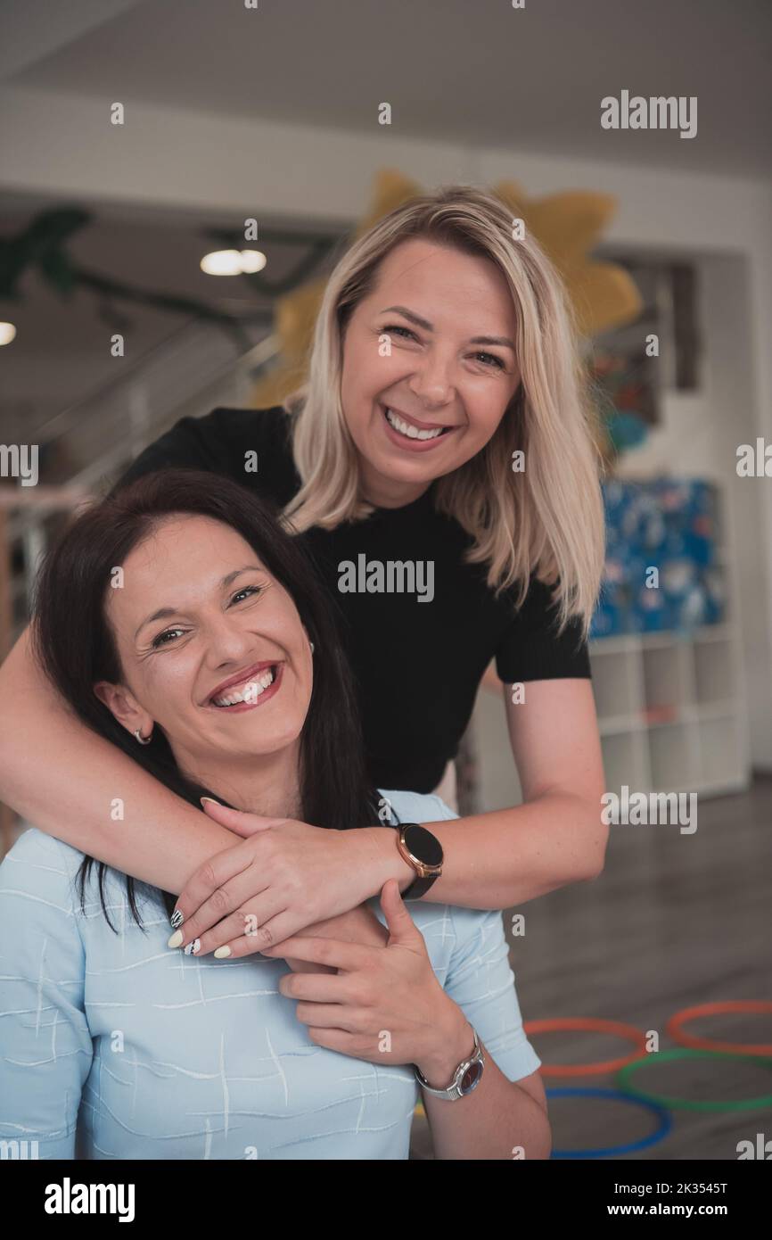 Portrait of two hugging female teachers in a preschool institution, in ...