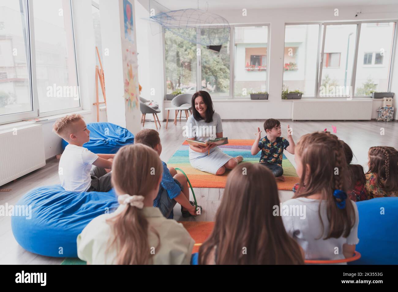 Reading time in an elementary school or kindergarten, a teacher reads a ...