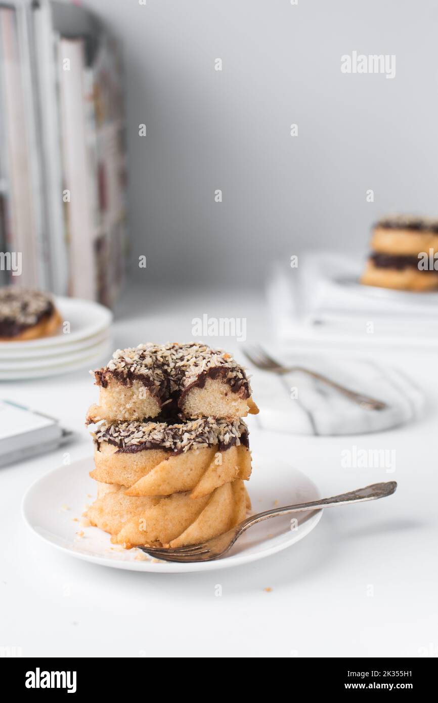 Tall stack of mini bundt cakes with chocolate glaze and coconut ...