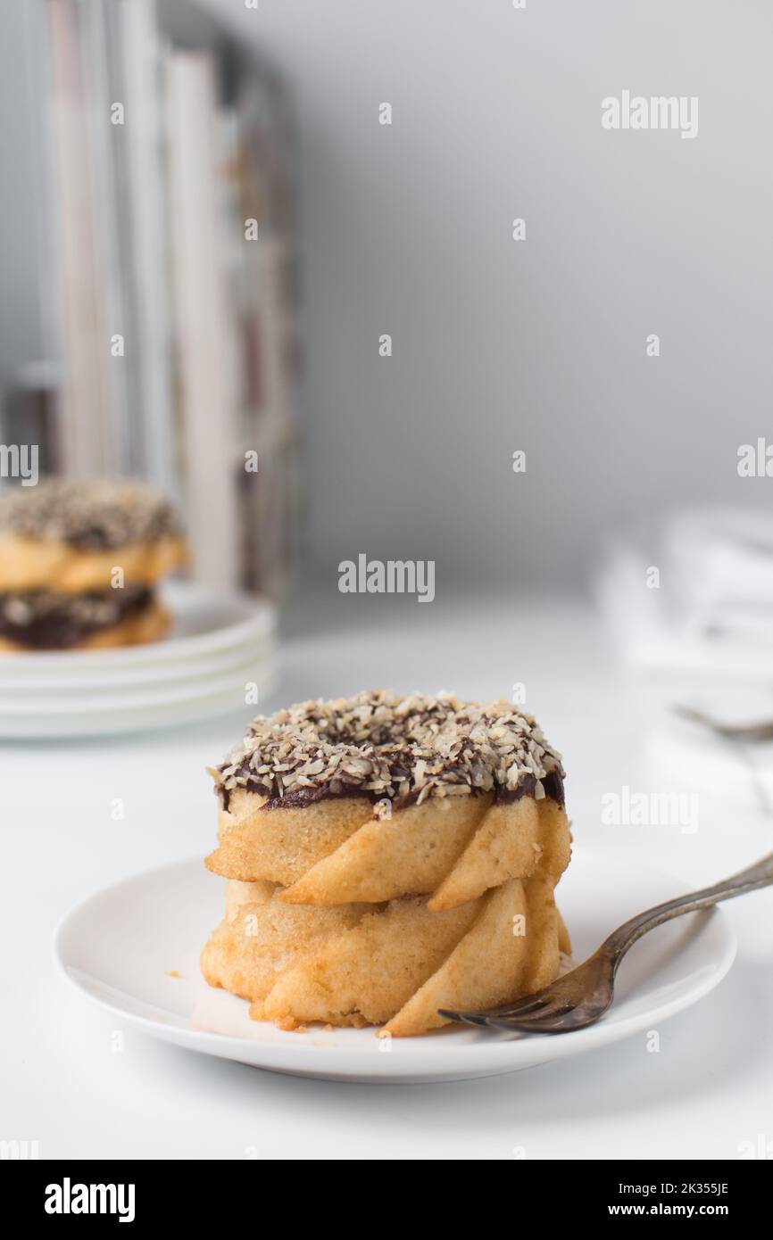 Tall stack of mini bundt cakes with chocolate glaze and coconut ...