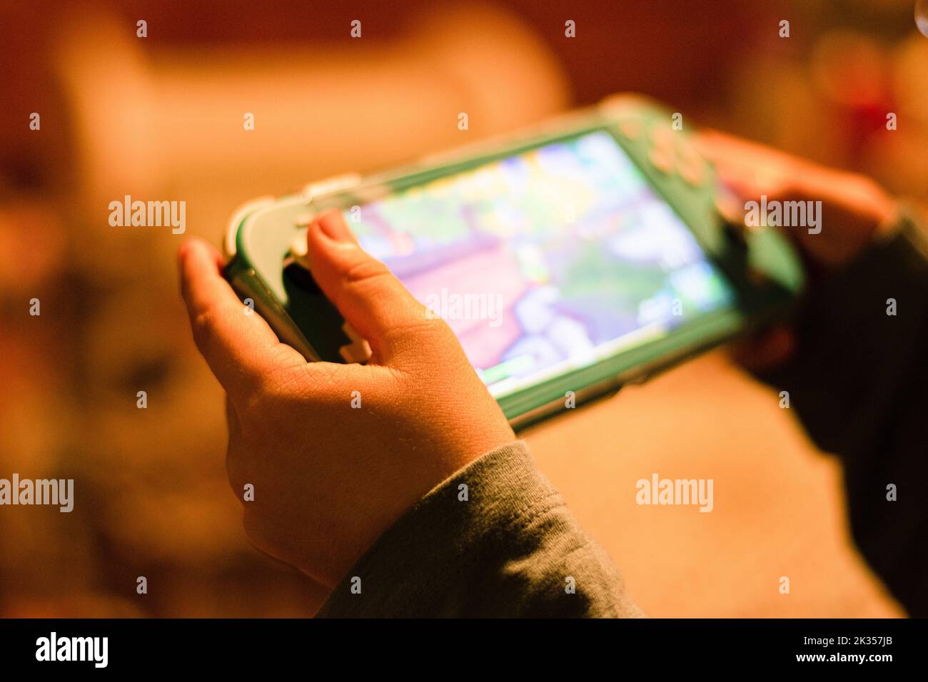 A child holding and playing a video game console Stock Photo - Alamy