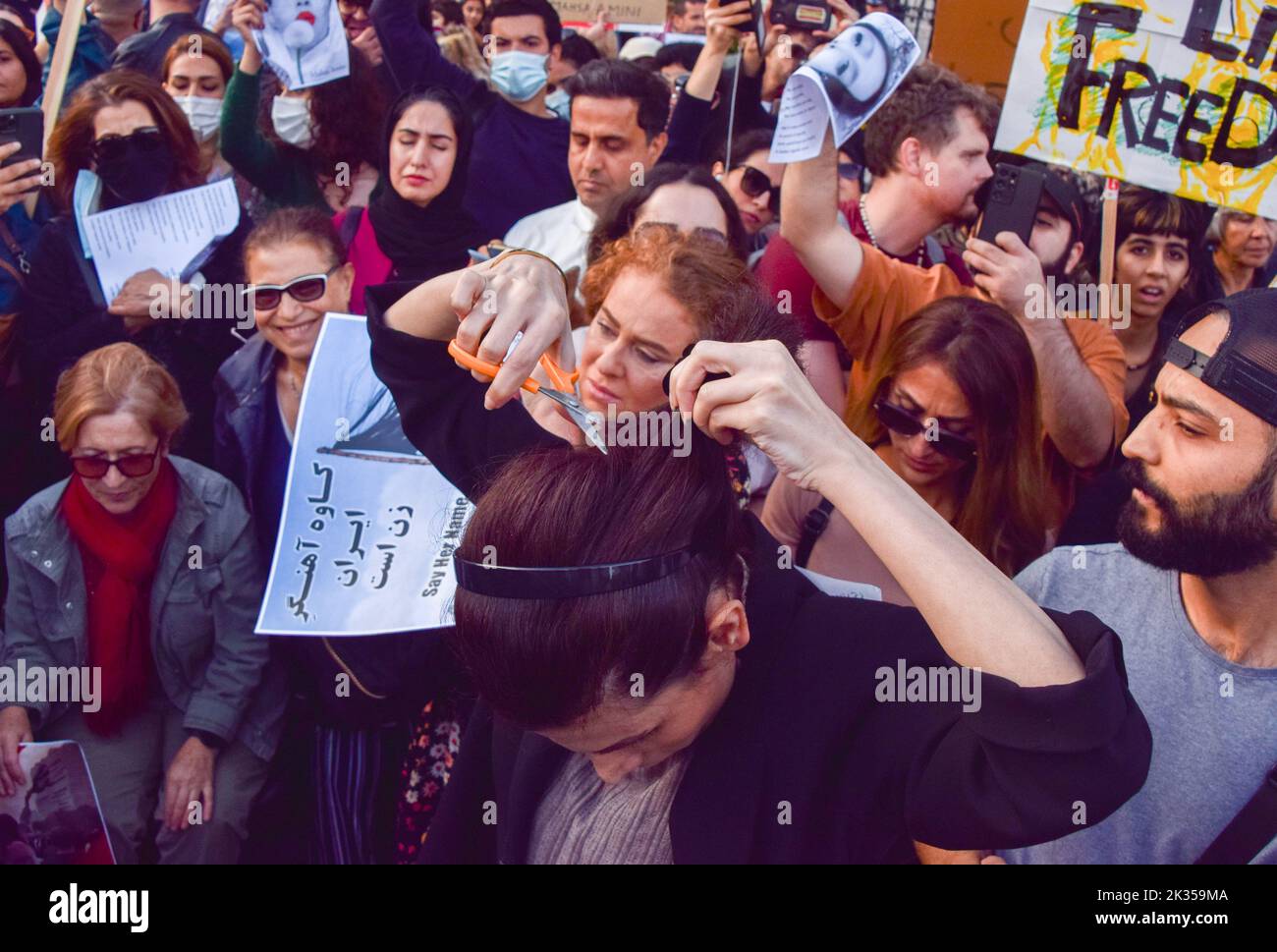 London, UK. 24th Sep, 2022. An Iranian woman cuts off a lock of her ...