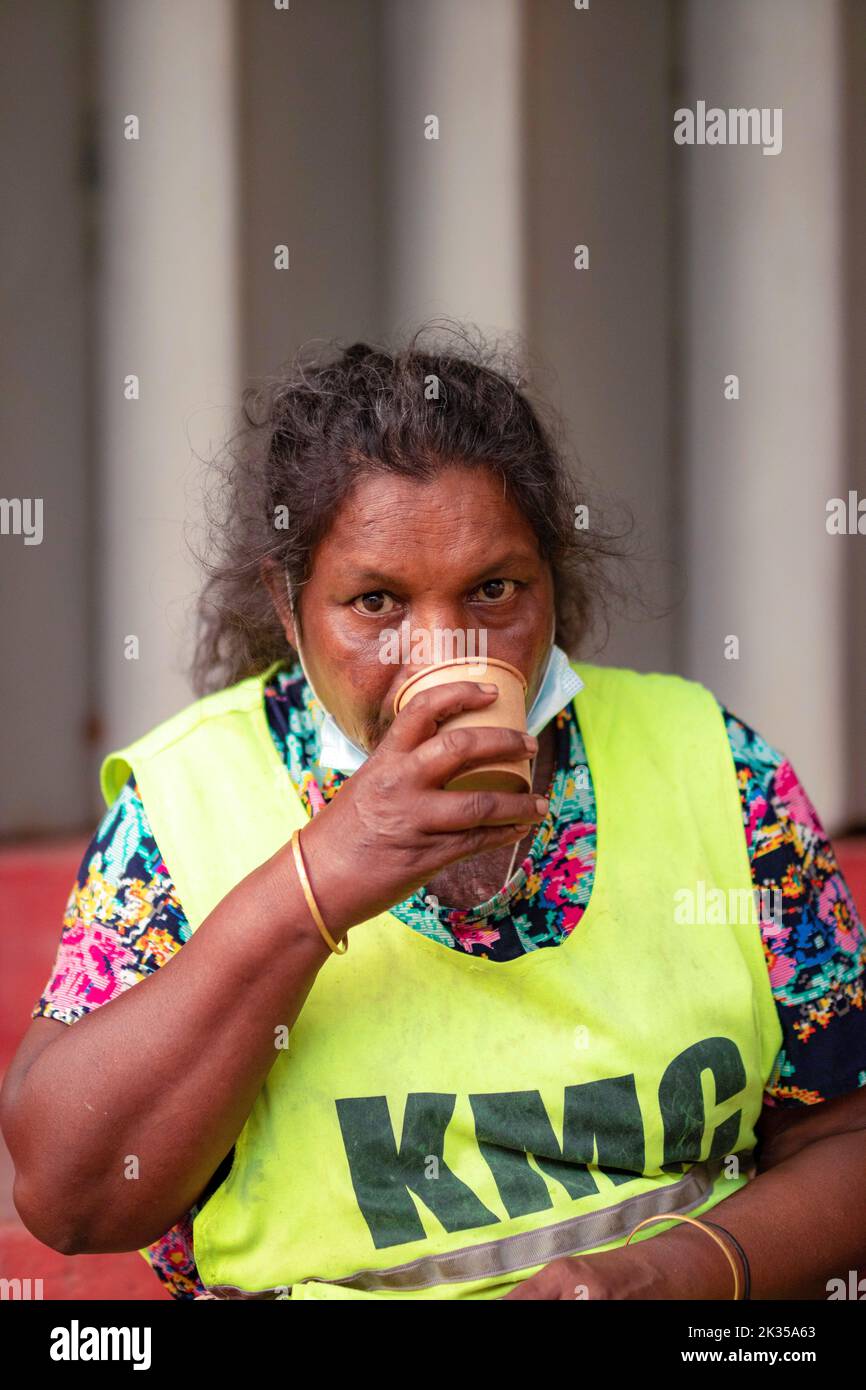 A Poor street cleaning lady having a break in Sri Lanka Stock Photo - Alamy