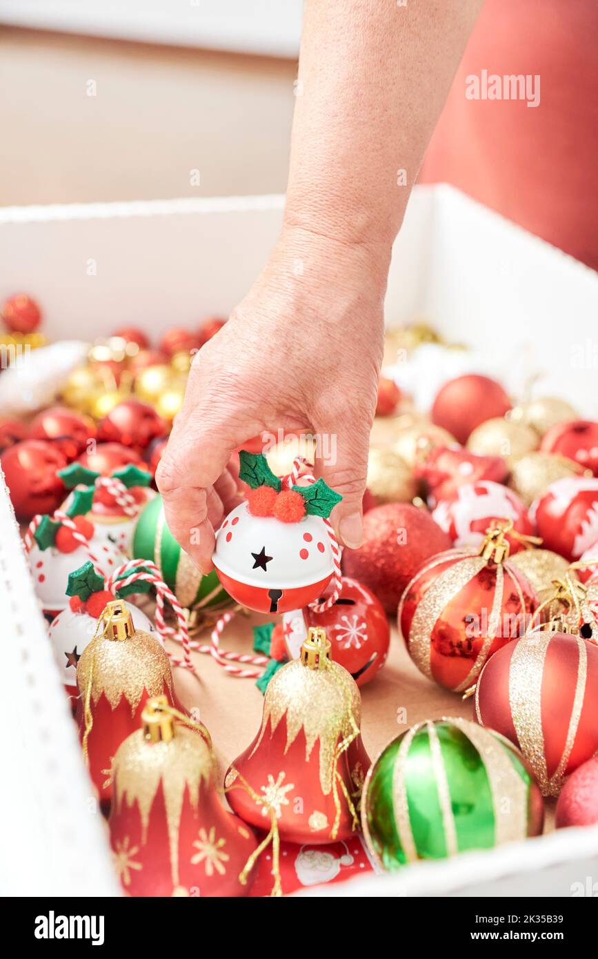 Female hand grabbing a ball from a box of mixed Christmas tree ...