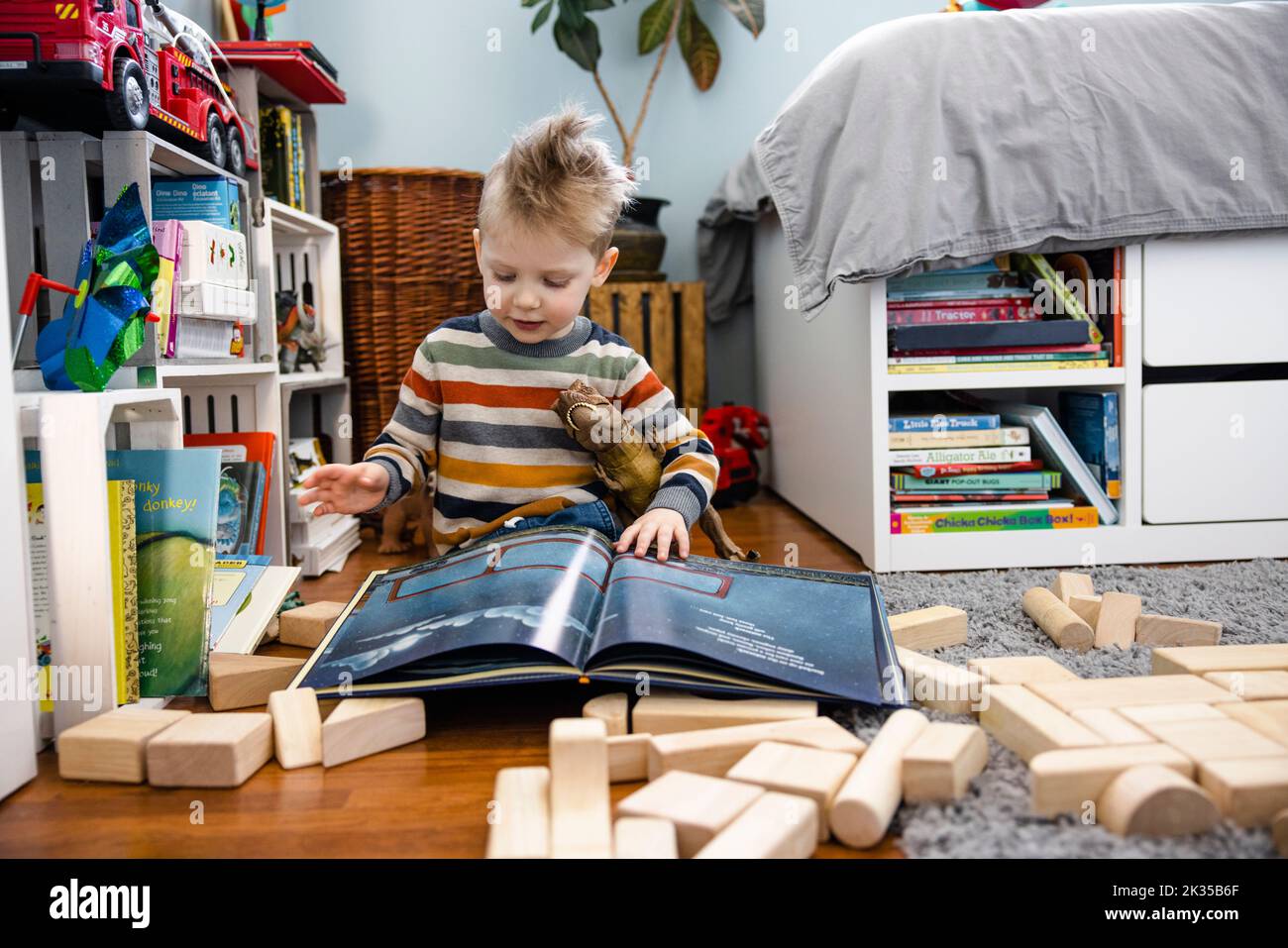 Boy sitting on floor reading book hi-res stock photography and images ...