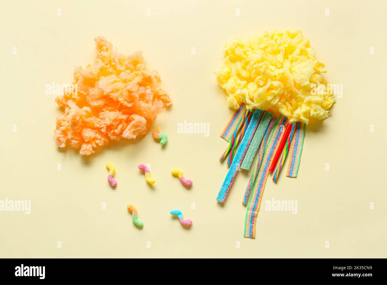 Composition with cotton candy clouds and different sweets on yellow ...