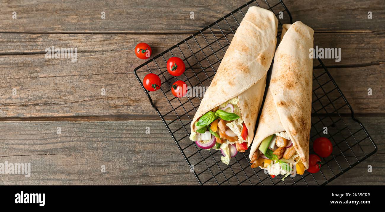 Tasty doner kebabs and tomatoes on wooden background with space for ...