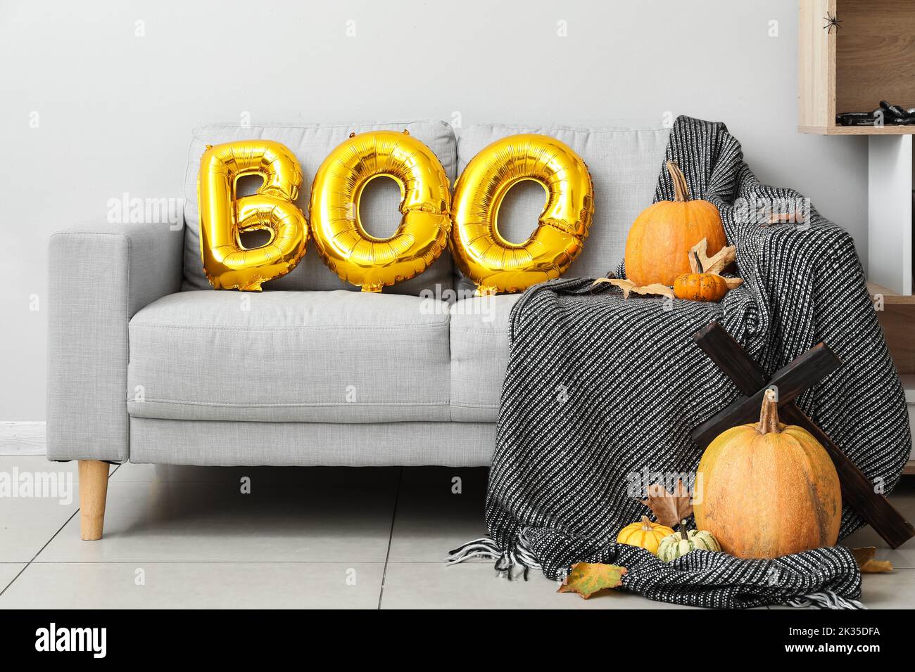Sofa with word BOO made of balloons, Halloween pumpkins, leaves and ...