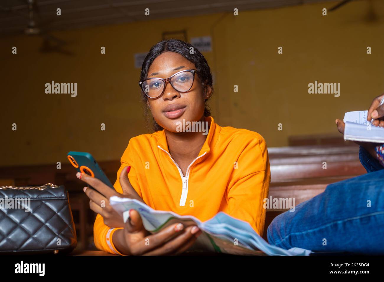 A portrait of an African pretty high school student using her phone in ...