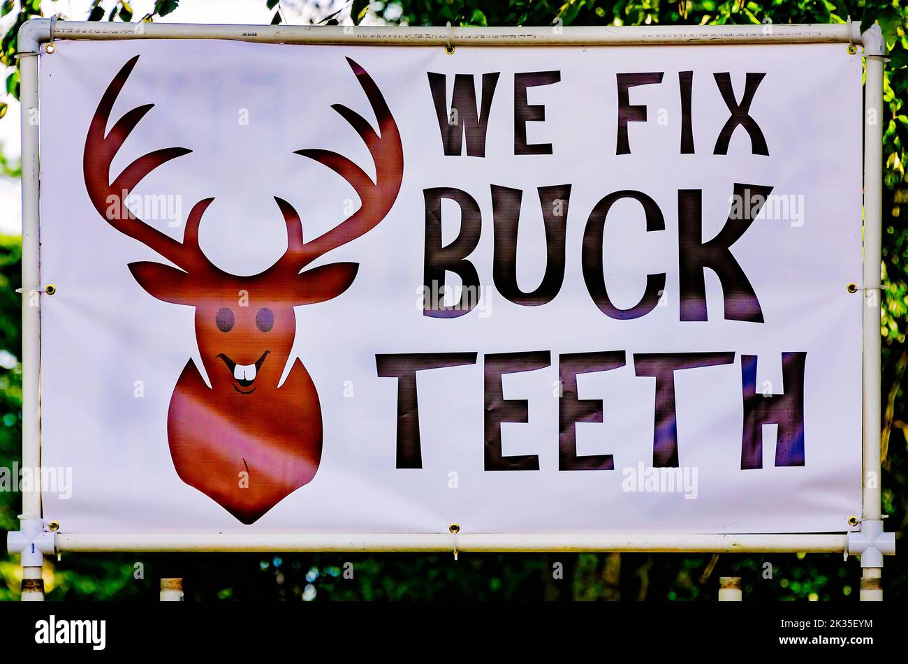 A sign in front of Glass Orthodontics advertises, “We fix buck teeth ...