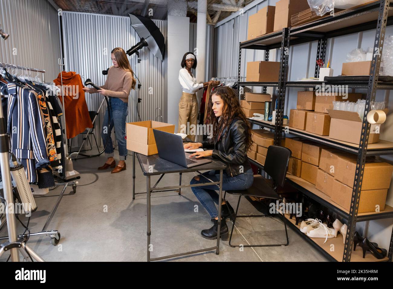Female fashion entrepreneurs working in storage facility locker Stock ...