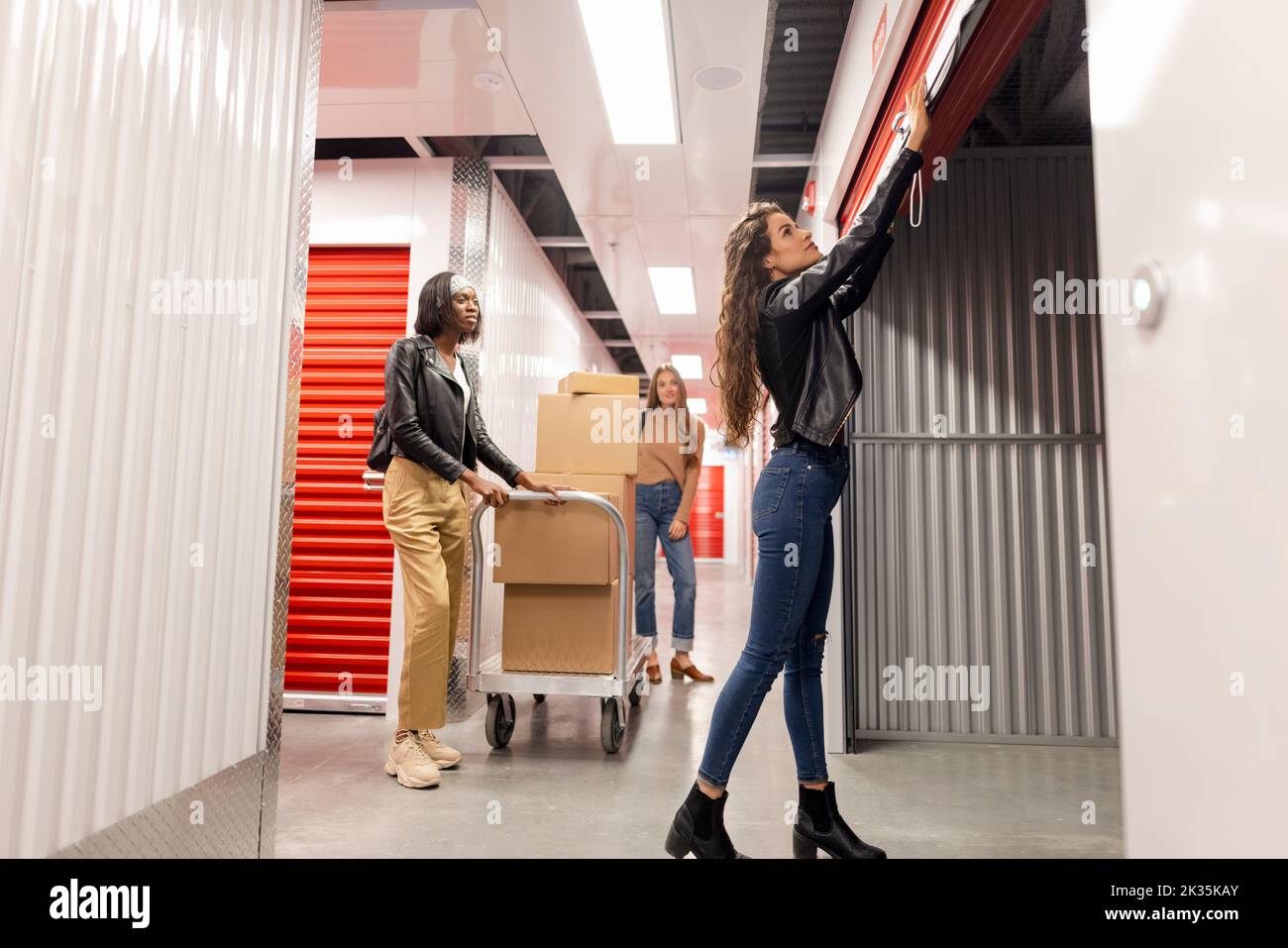 Women friends with boxes opening storage facility locker Stock Photo ...