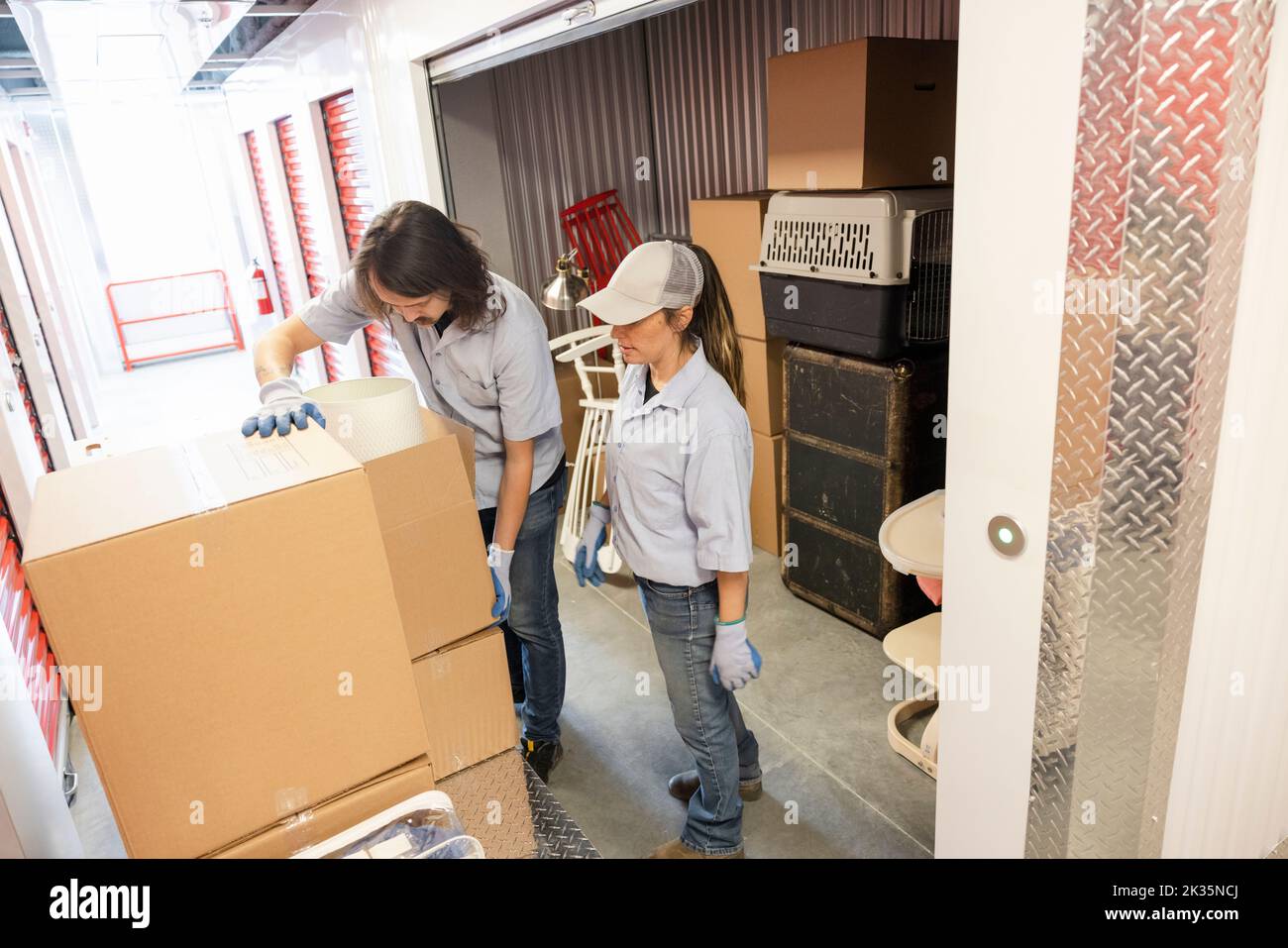 Movers with boxes at storage facility locker Stock Photo - Alamy