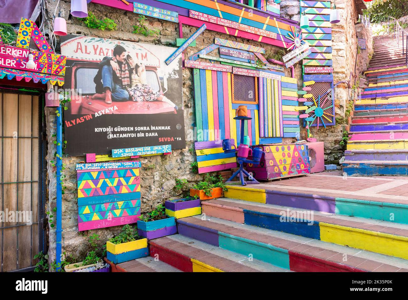 Exterior daytime shot of stone cafe decorated with multicolored panels ...