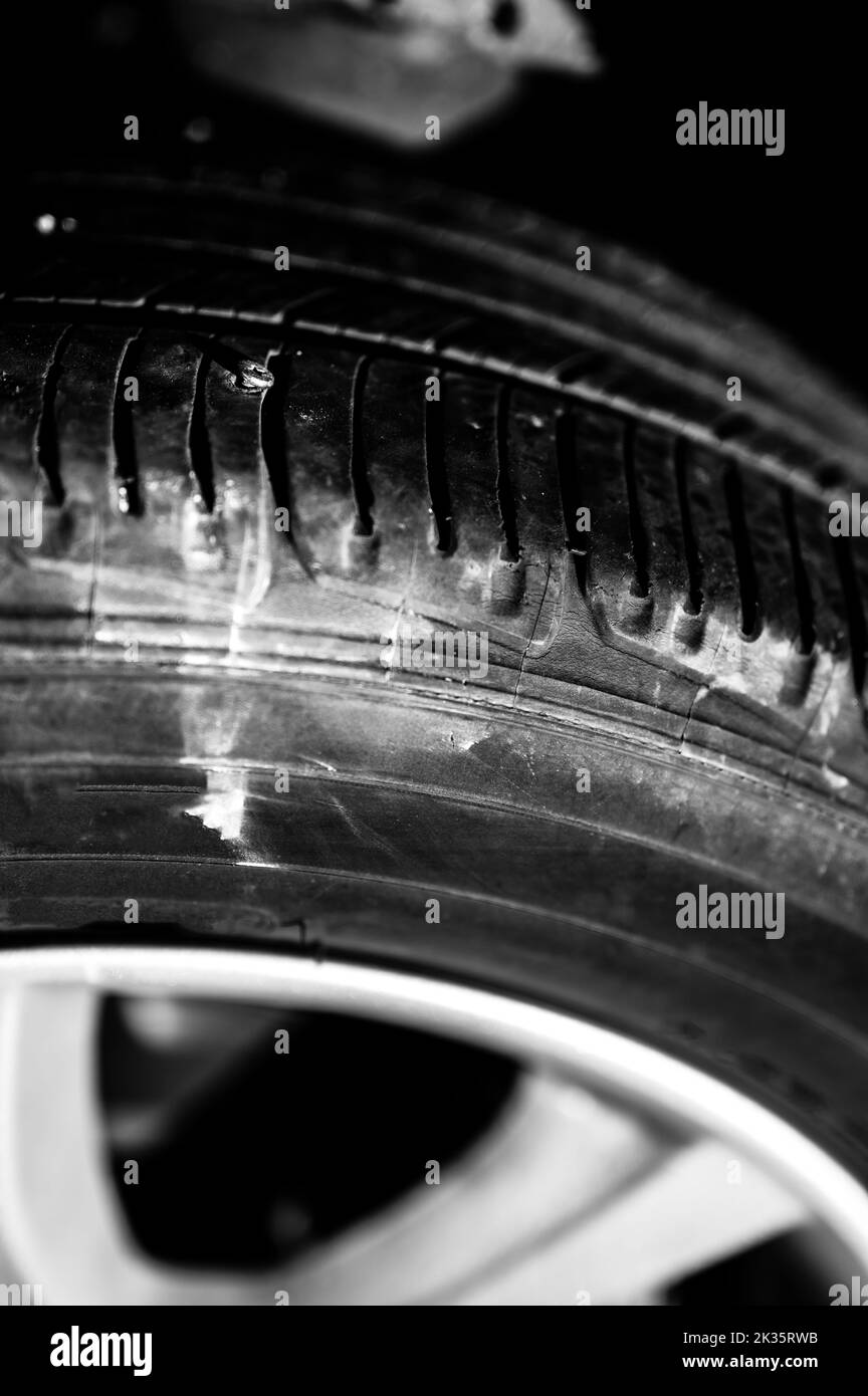 screw protruding from the tread of a tire causing a flat Stock Photo ...