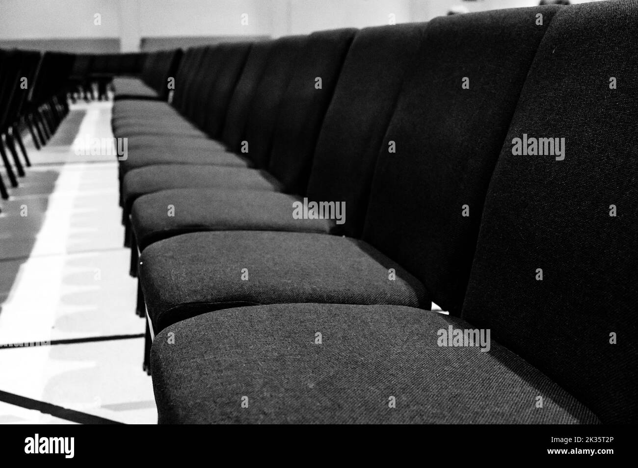 selective focus on a padded seat cushion of a row of chairs in a ...