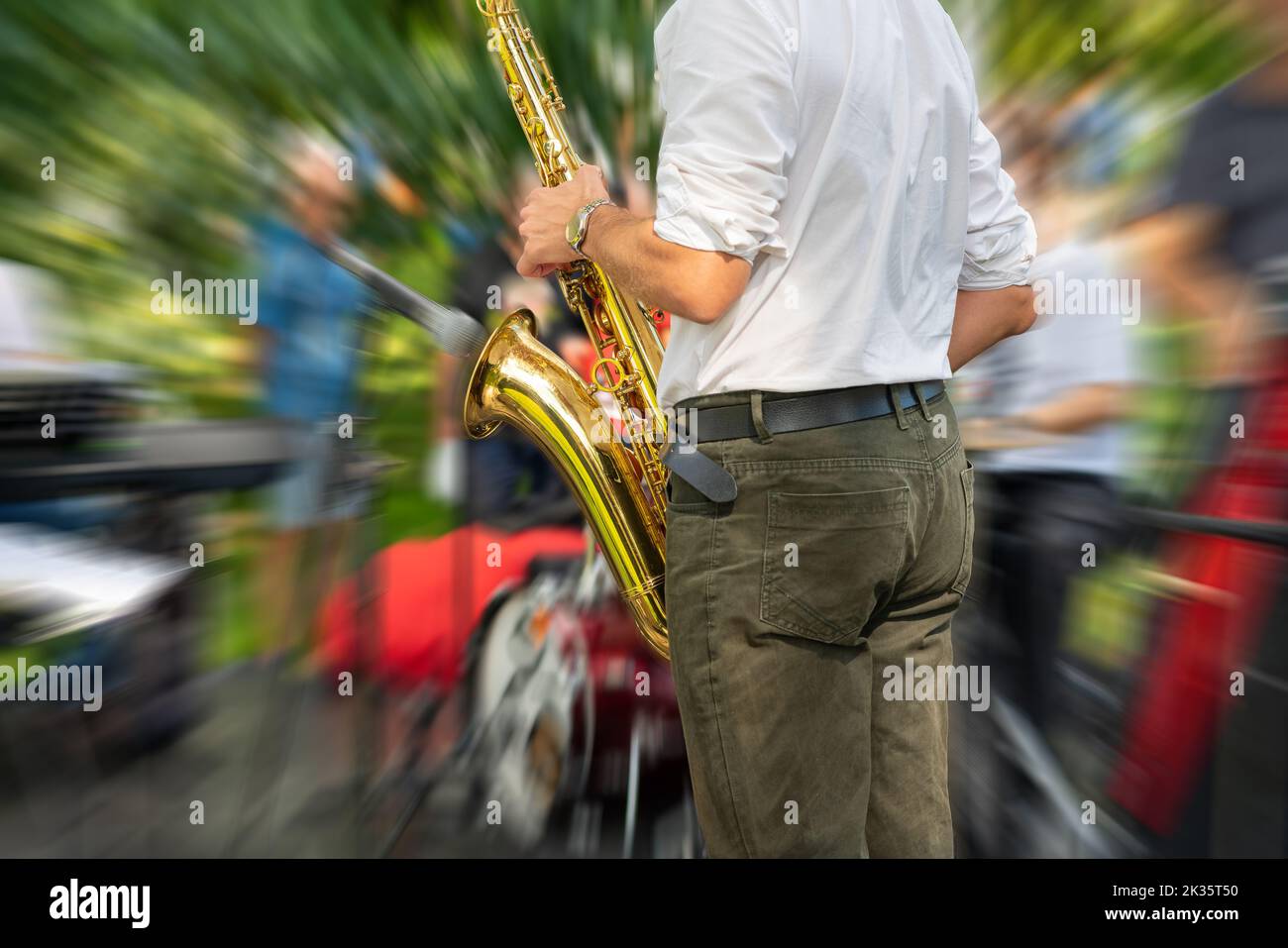 Saxophonist playing saxophone with blurred dynamic background during ...