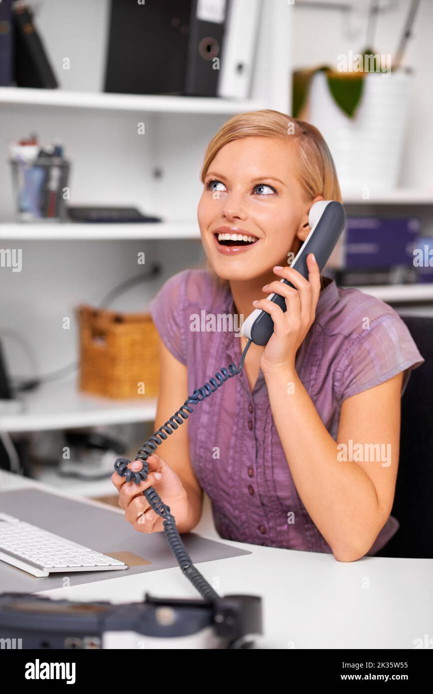 Taking a guess at the answer. a beautiful young woman using a phone at ...
