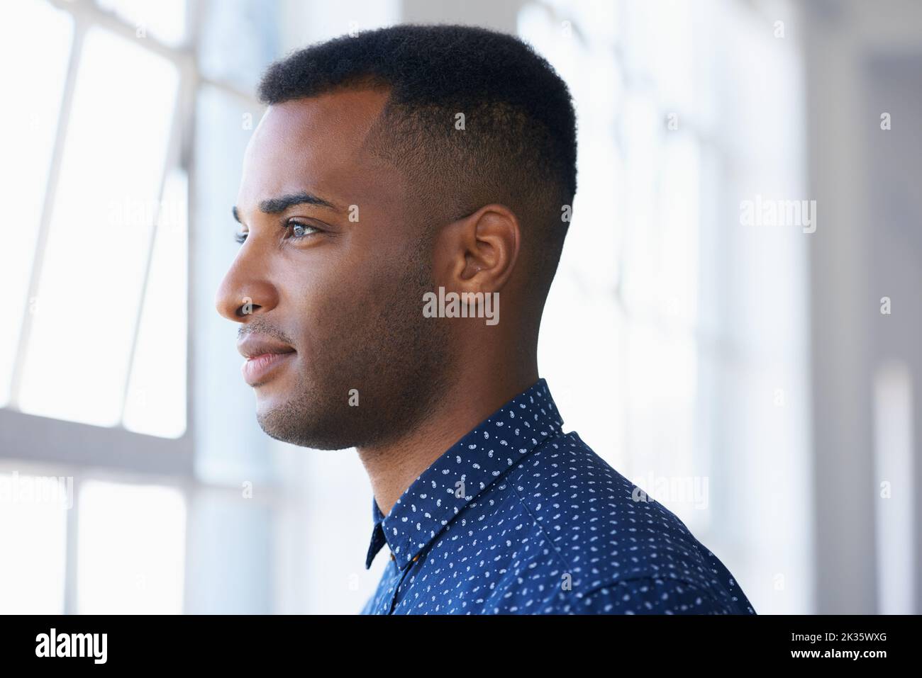 Contemplating his future. Profile of a young ethnic man looking ...