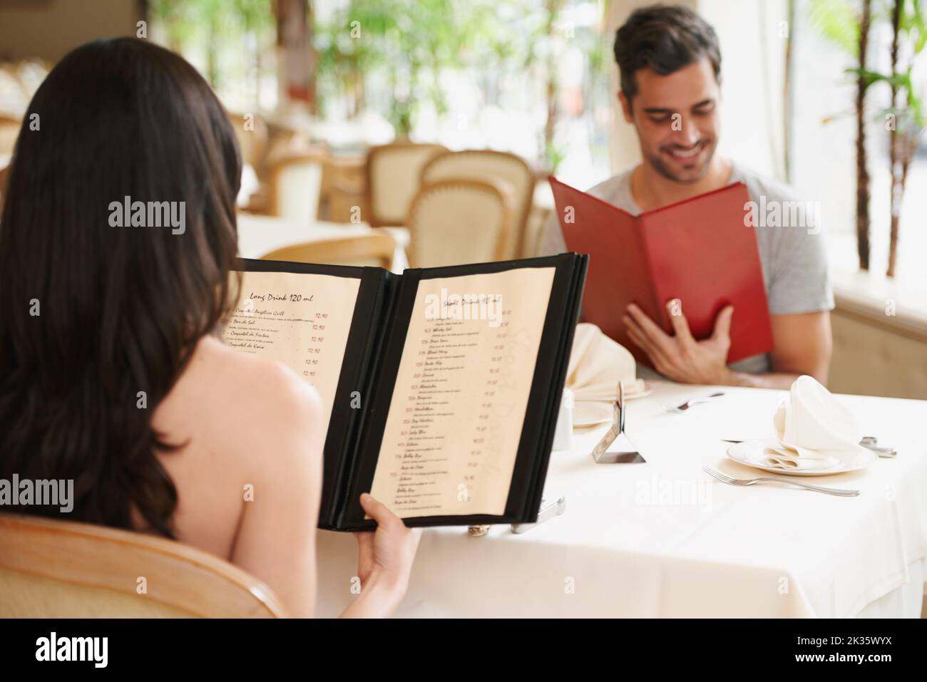 Celebrating their anniversary with delicious food. A happy young couple ...