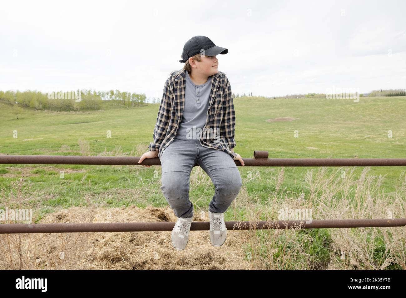 Boy sitting on fence hi-res stock photography and images - Alamy