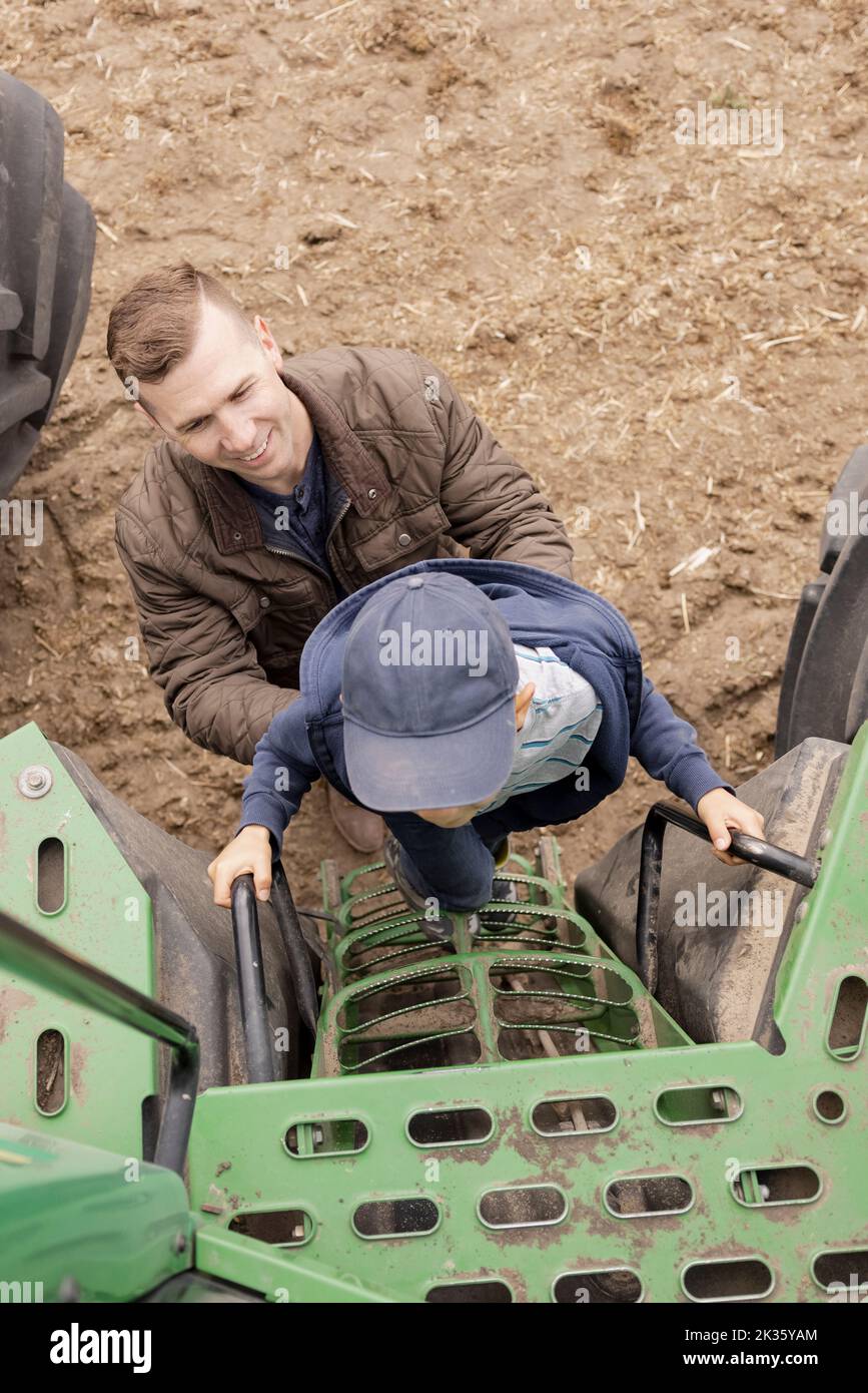 Father son watching combine harvester hi-res stock photography and ...