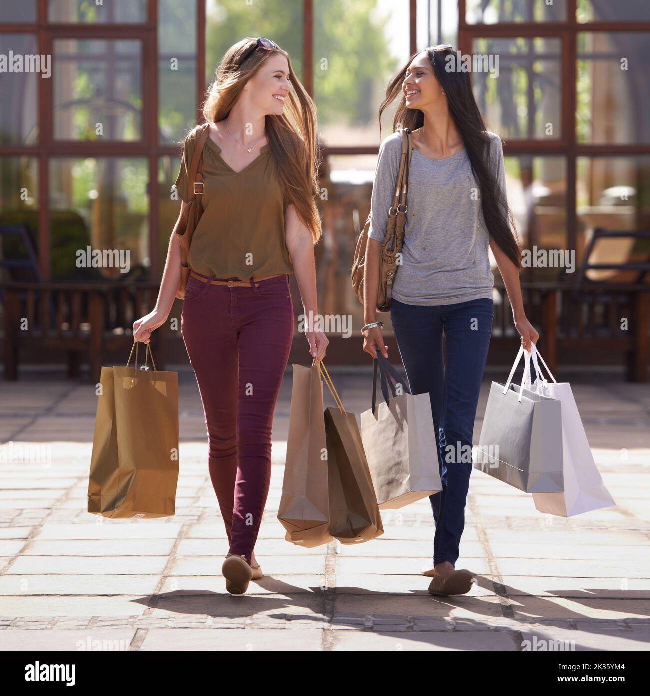A day well spent. Two young ladies walking away from the shopping mall ...