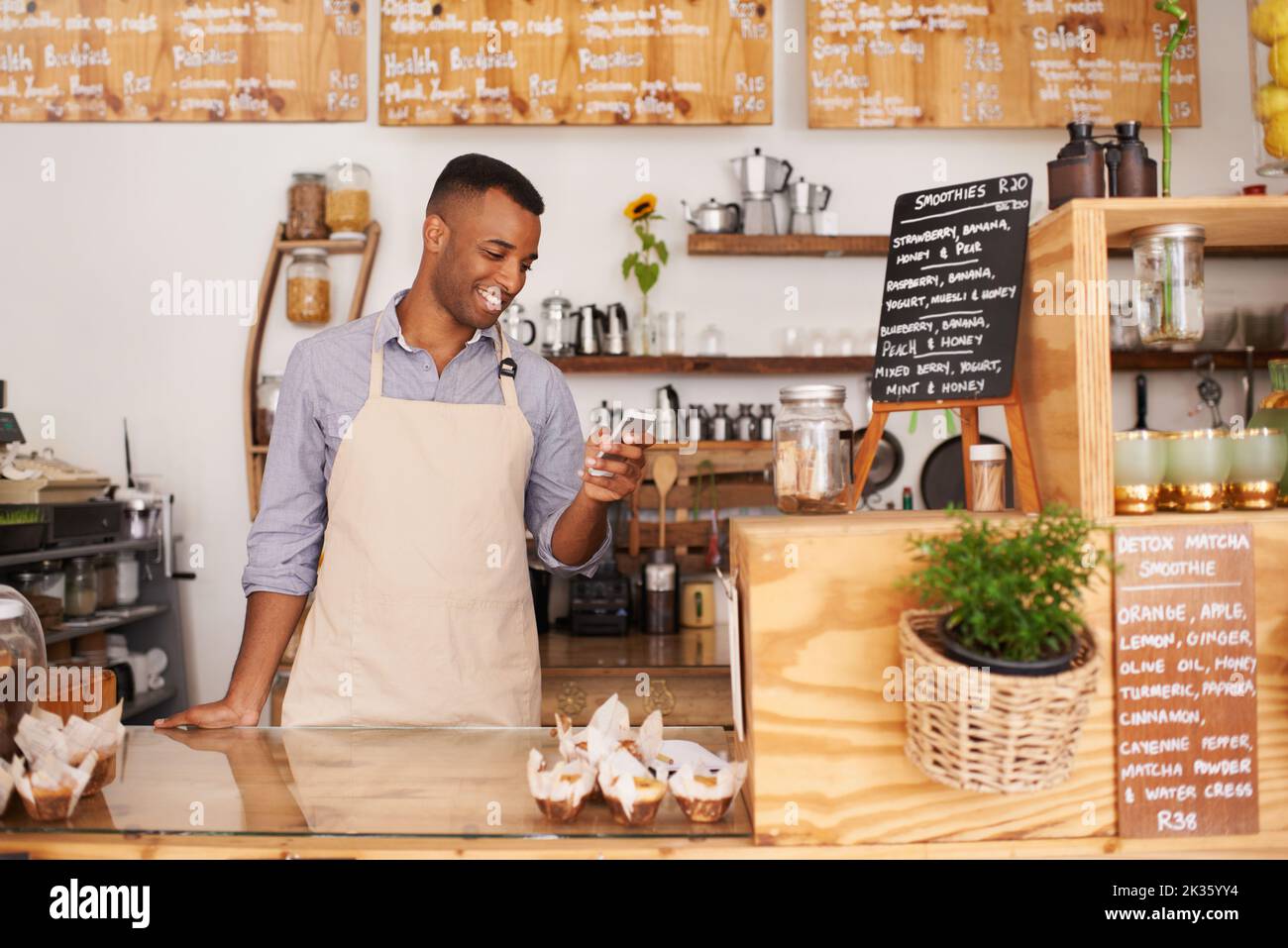 Proud of the cafe hes built. A handsome young man standing behind the ...