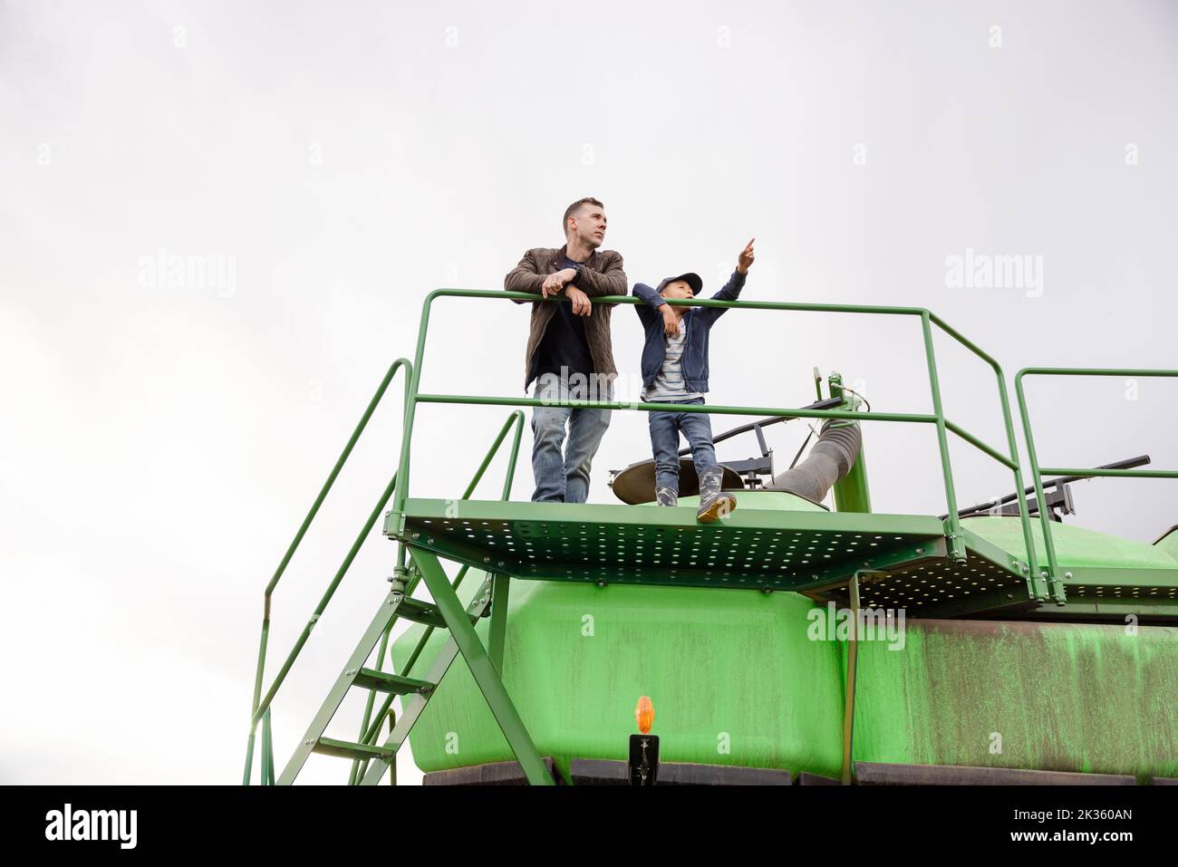Father son watching combine harvester hi-res stock photography and ...