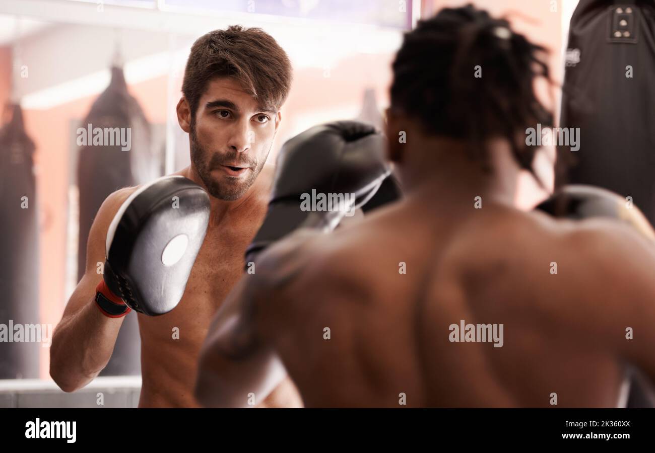 Brothers in boxing. a young boxer practicing his punching with a ...