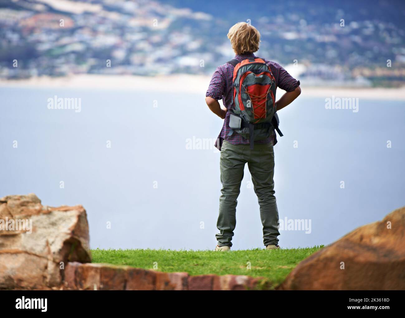 Awed by the beauty of nature. A young man with a backpack admiring the ...