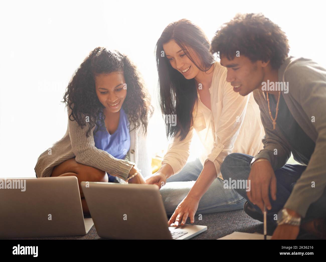 Tackling exam revision as a team. A group of college students sitting ...
