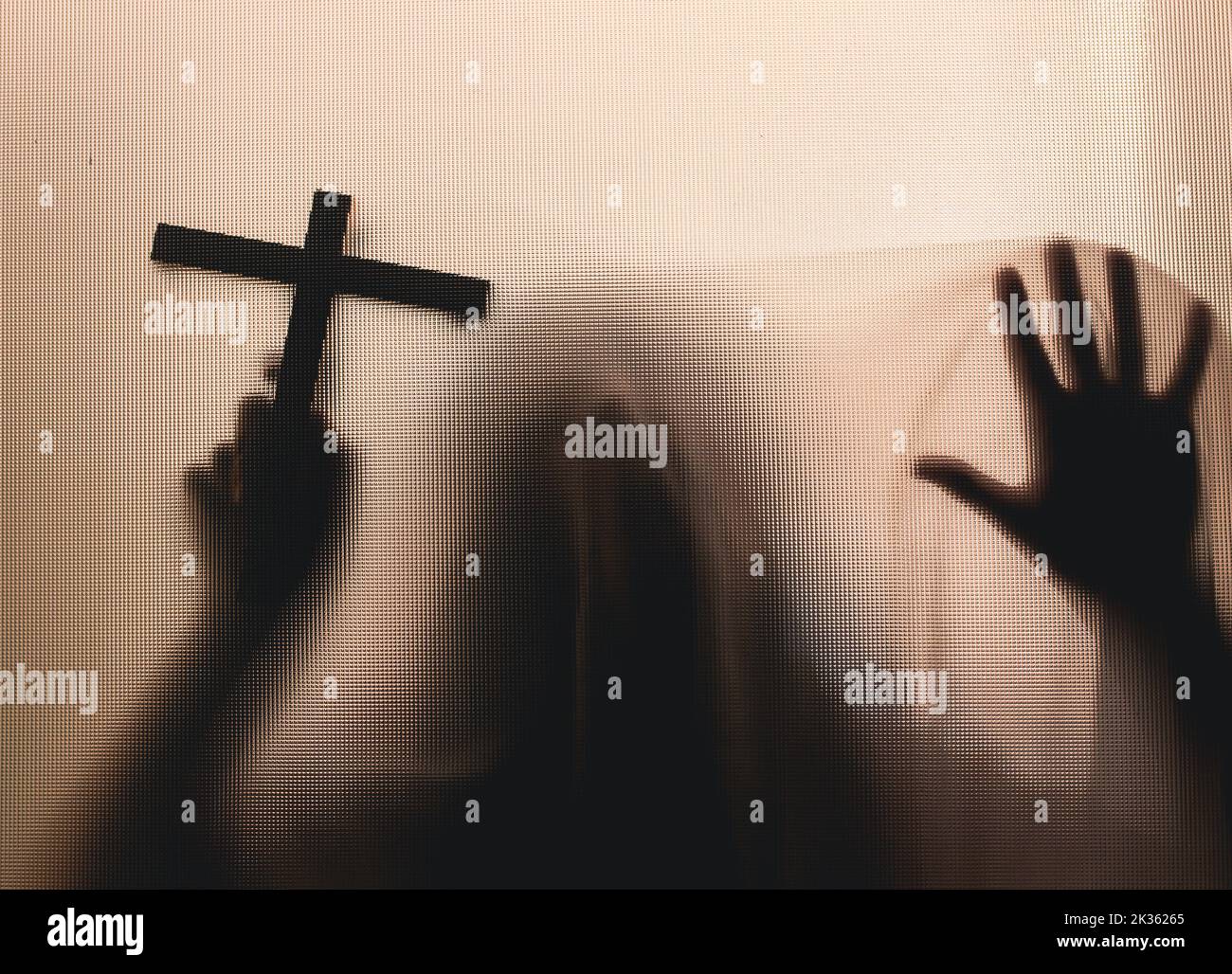 Horror ghost woman holding a cross behind the matte glass. Halloween ...