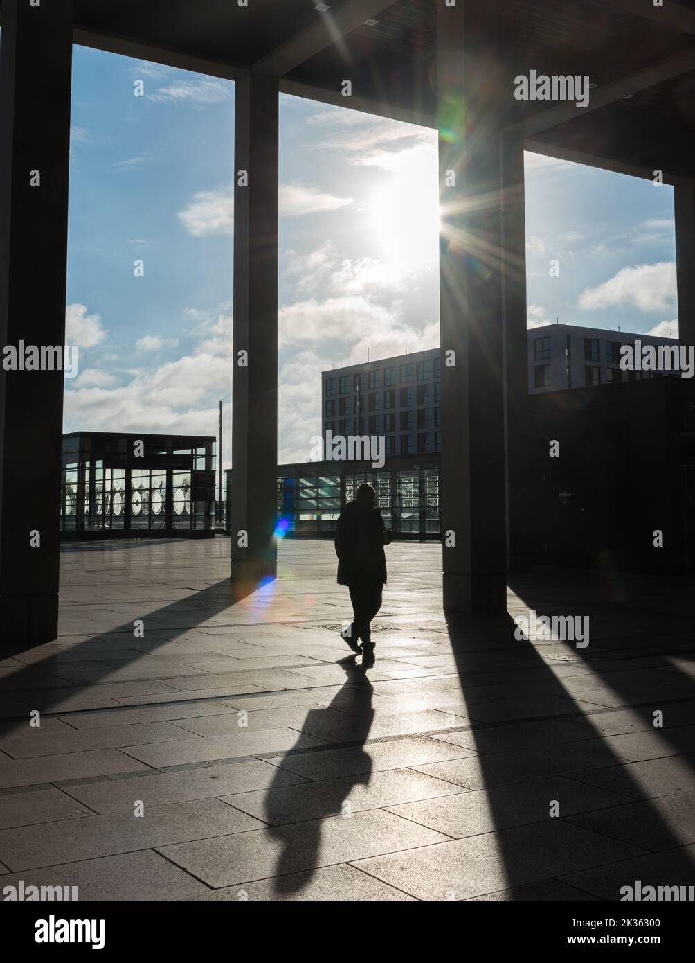 A man walks in a square with tall columns Stock Photo - Alamy