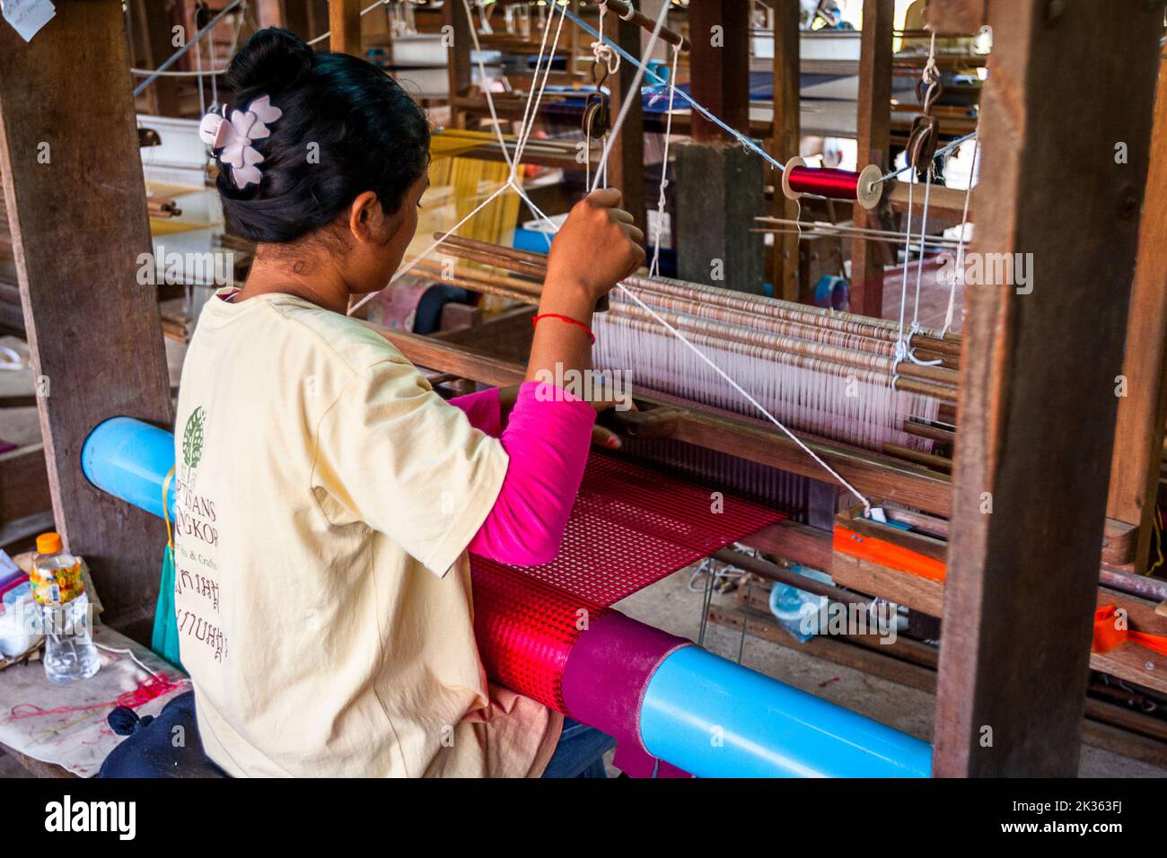 A female worker uses her machine to make fabric with the silk threads ...