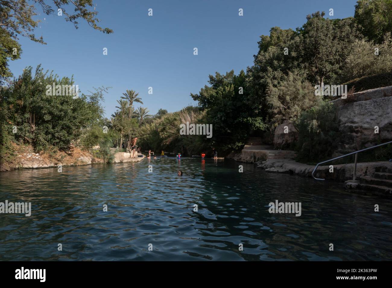 People bath in a natural spring water pool of Amal stream which crosses ...