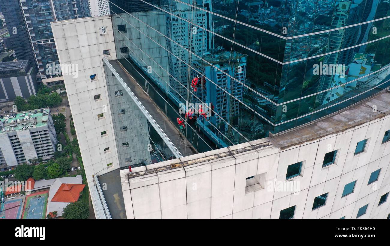 Four Window Washers Cleaning on the side of a skyscraper. Washers in ...