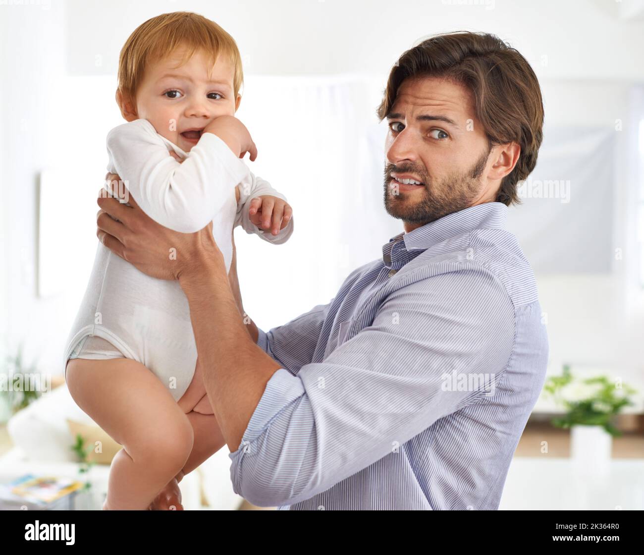 Someone needs changing. a handsome father holding his son up in the air ...