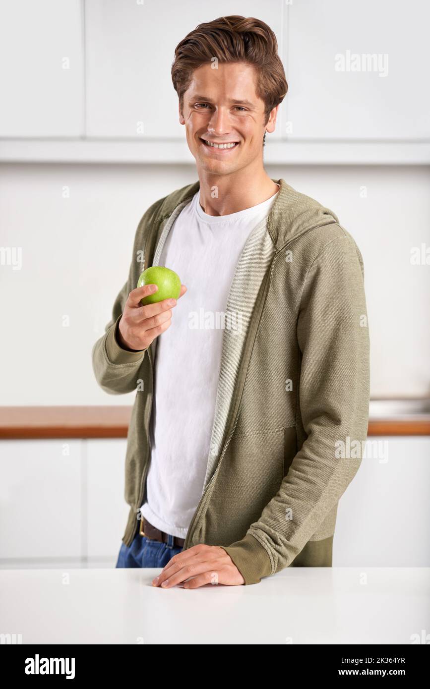 Starting his day off the healthy way. Portrait of a handsome young man ...