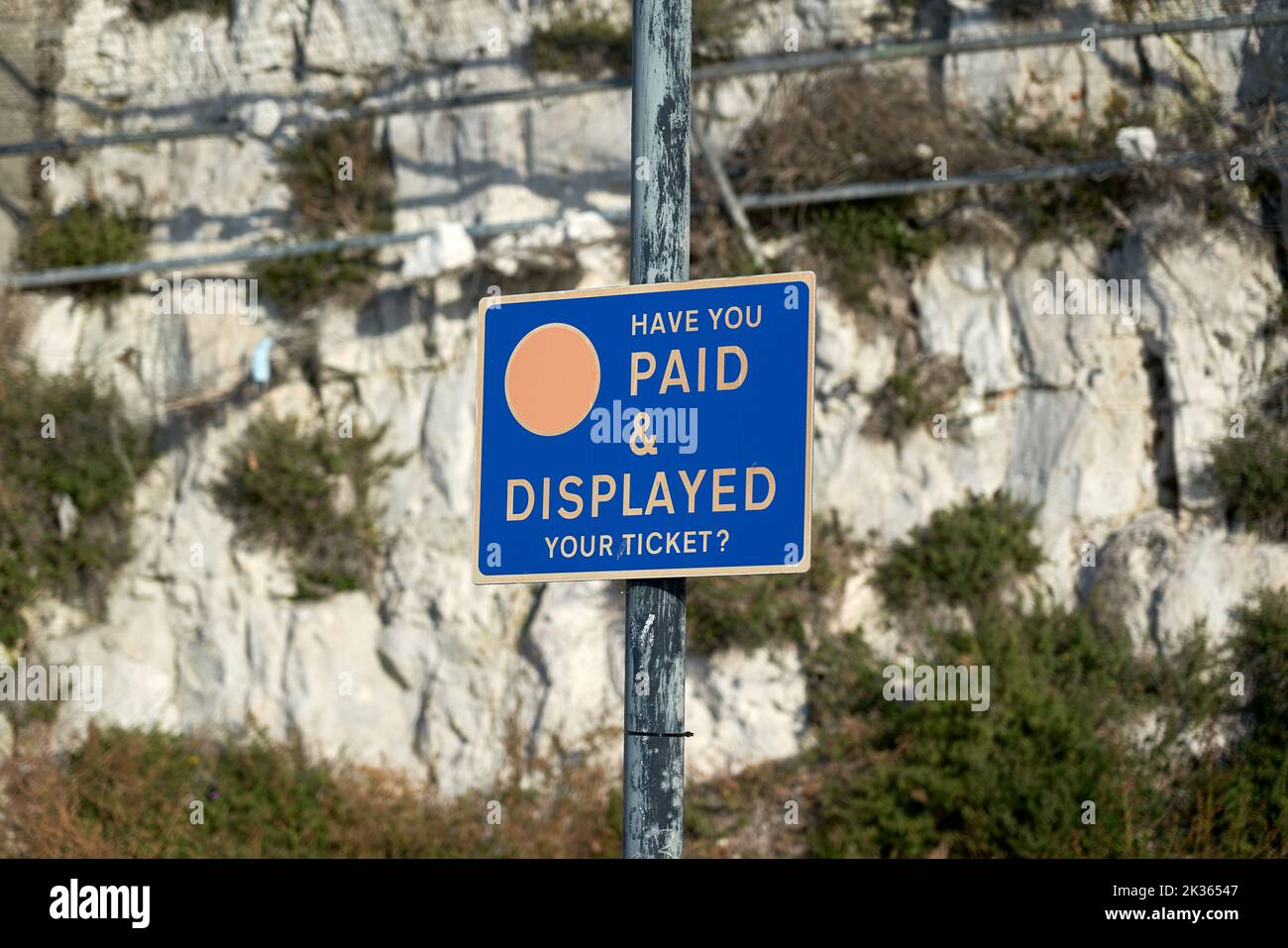 A blue pay and display car park sign with rocks in the background Stock ...