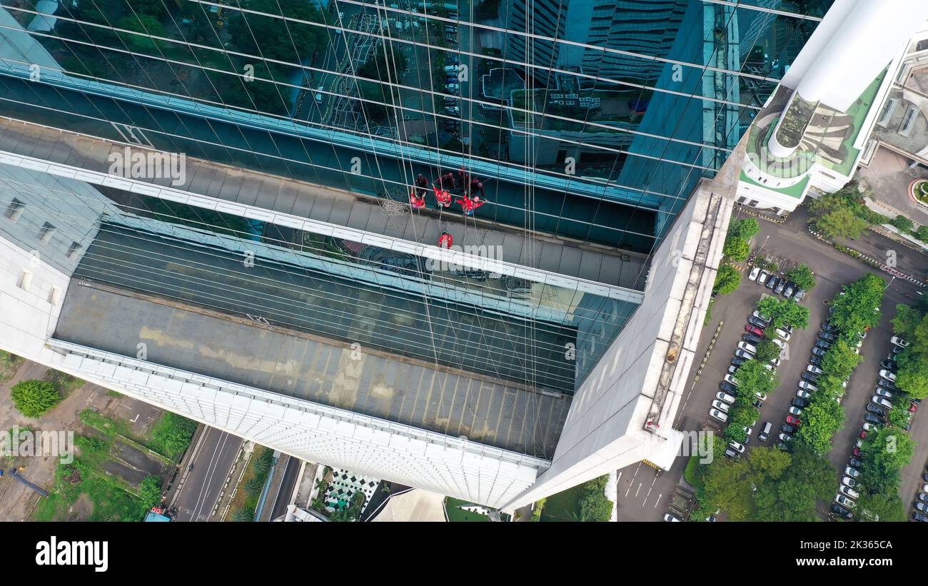 Aerial top down view of window cleaners working on a glass facade ...
